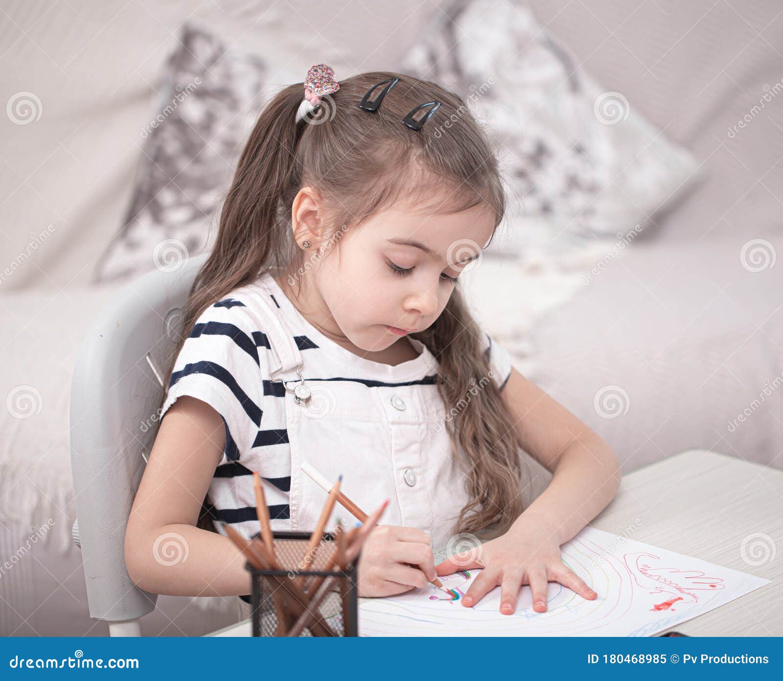 The Girl is Sitting at the Table and Doing Homework. the Child Learns ...