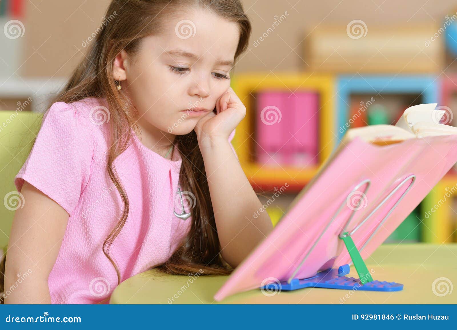 Girl is Sitting at the Table and Reading a Book Stock Photo - Image of ...
