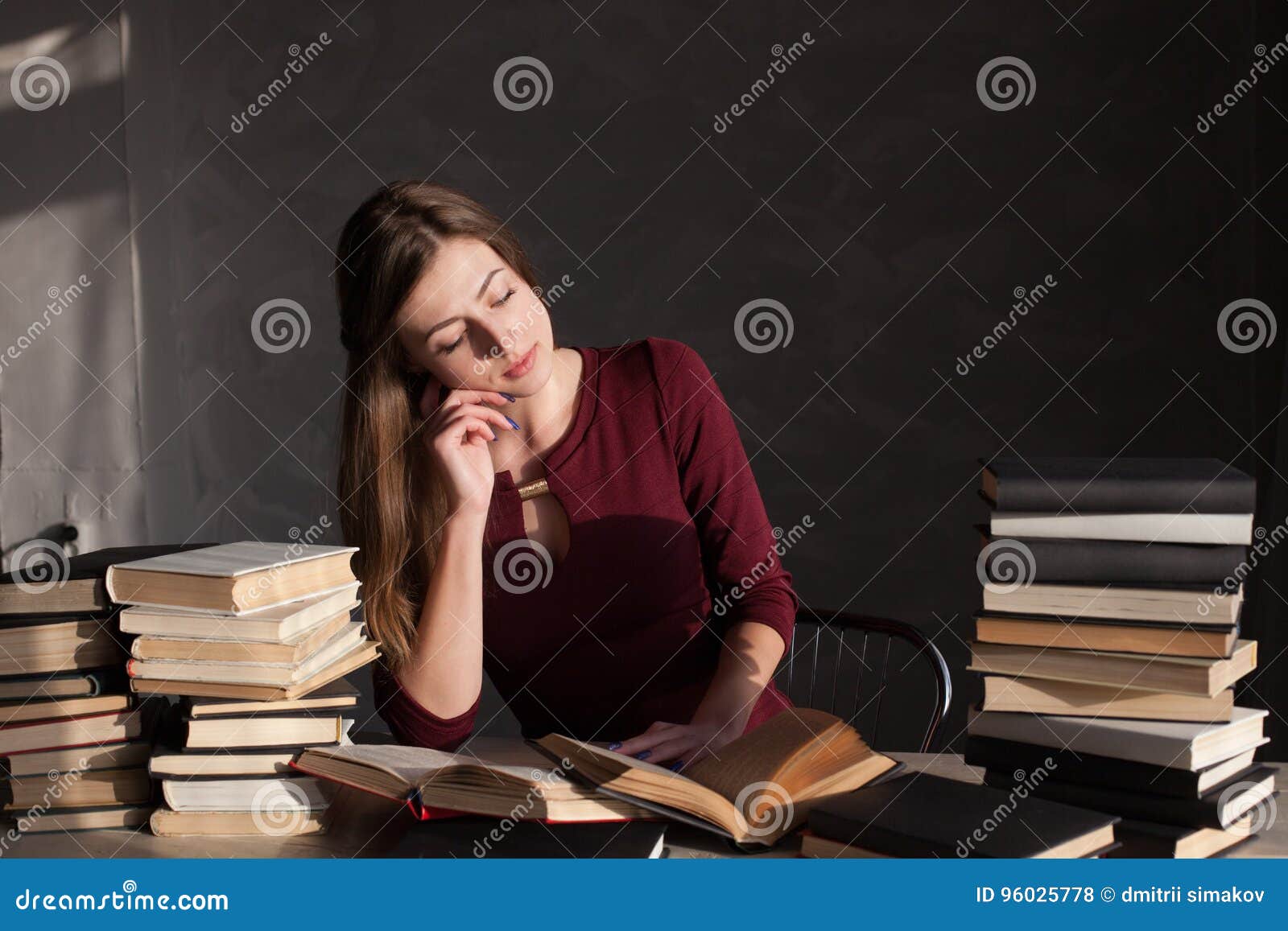 The Girl Sitting at the Table Reading a Lot of Books Stock Photo ...