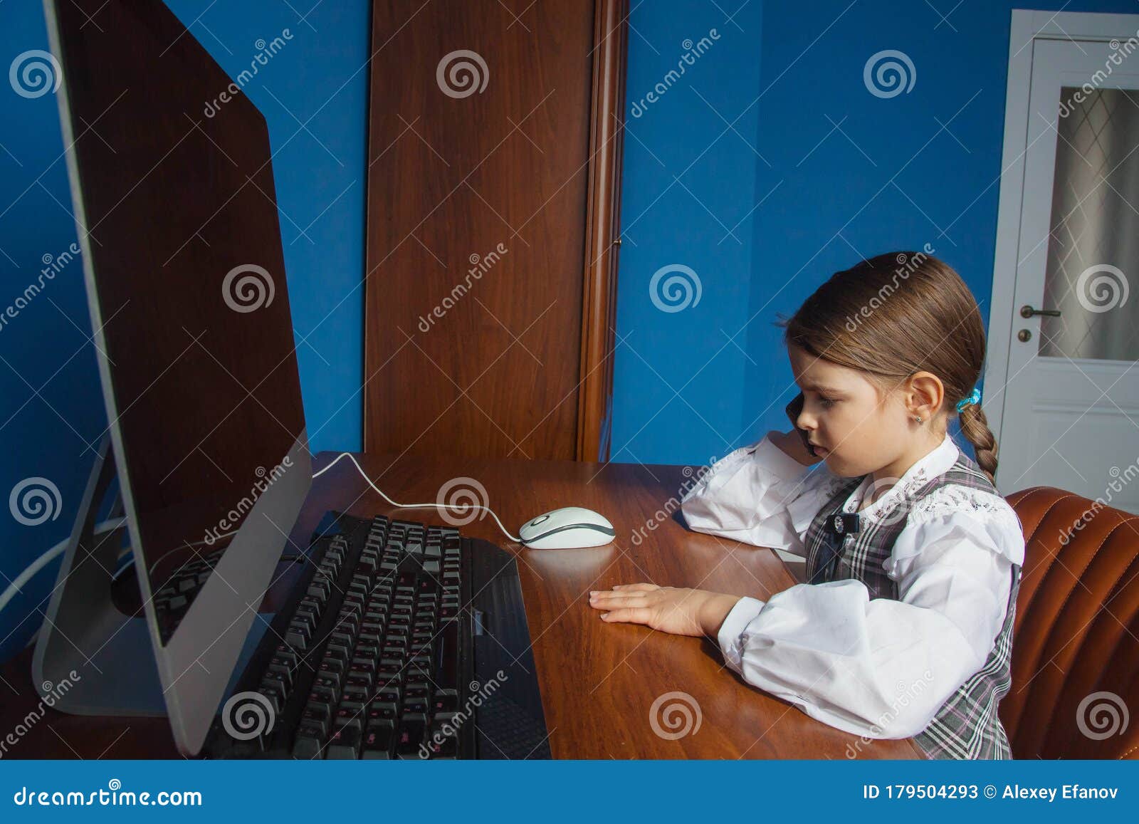 Girl is Sitting at the Table and Working and Studying at the Computer ...