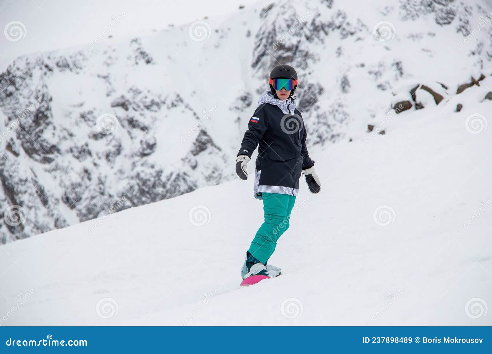 A Girl on a Snowboard Rides Down the Side of the Mountain Stock Image ...