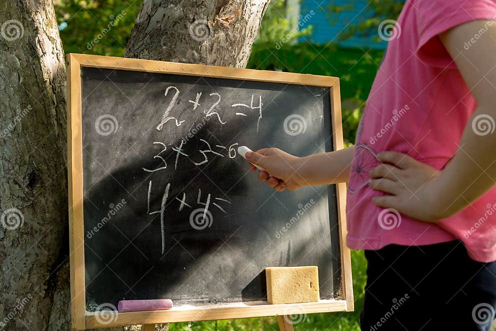 Girl Solves Mathematical Examples on a Slate Board in Summer in the ...