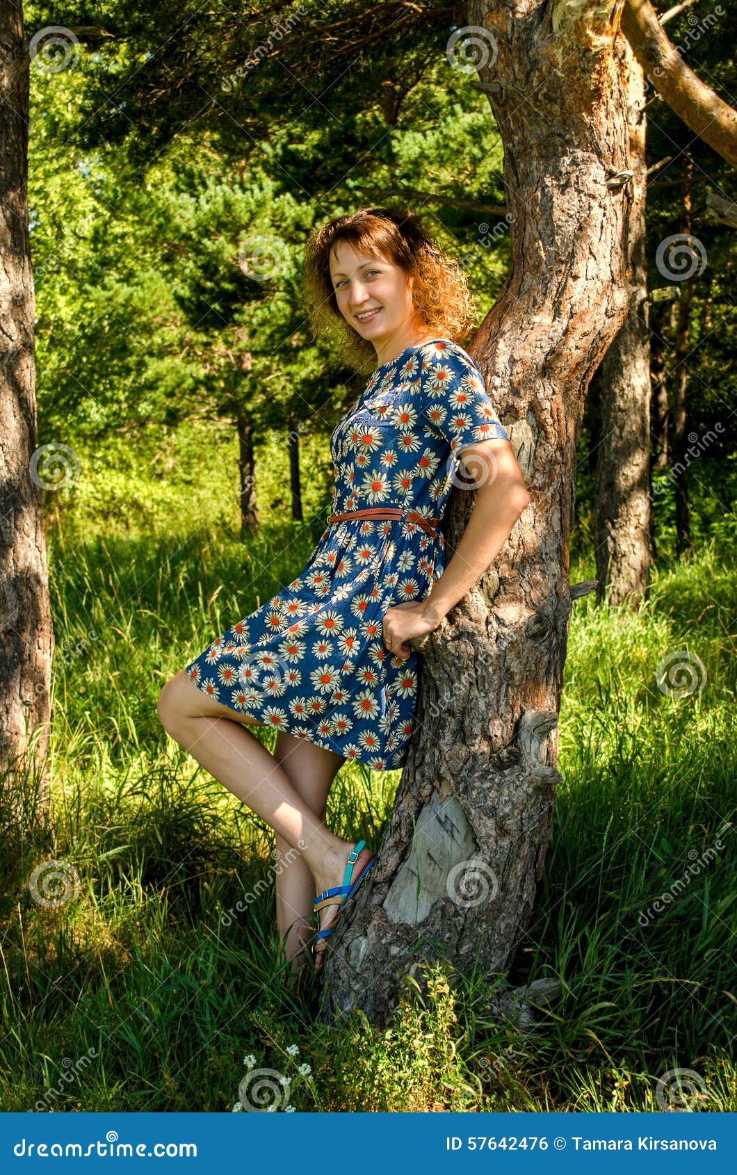 A girl stands near a tree stock photo. Image of stands - 57642476