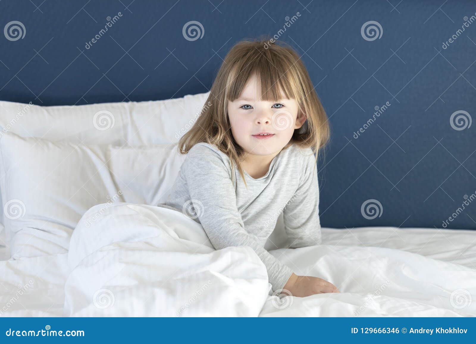 Girl stretching on the bed stock photo. Image of girl - 129666346