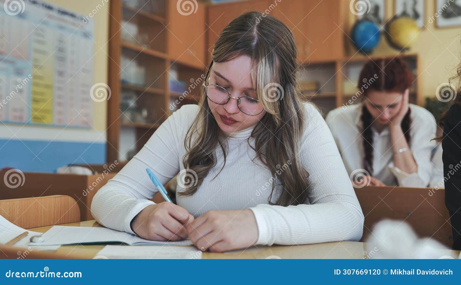 A Girl Student Writes Math Formulas in a Notebook. Stock Photo - Image ...