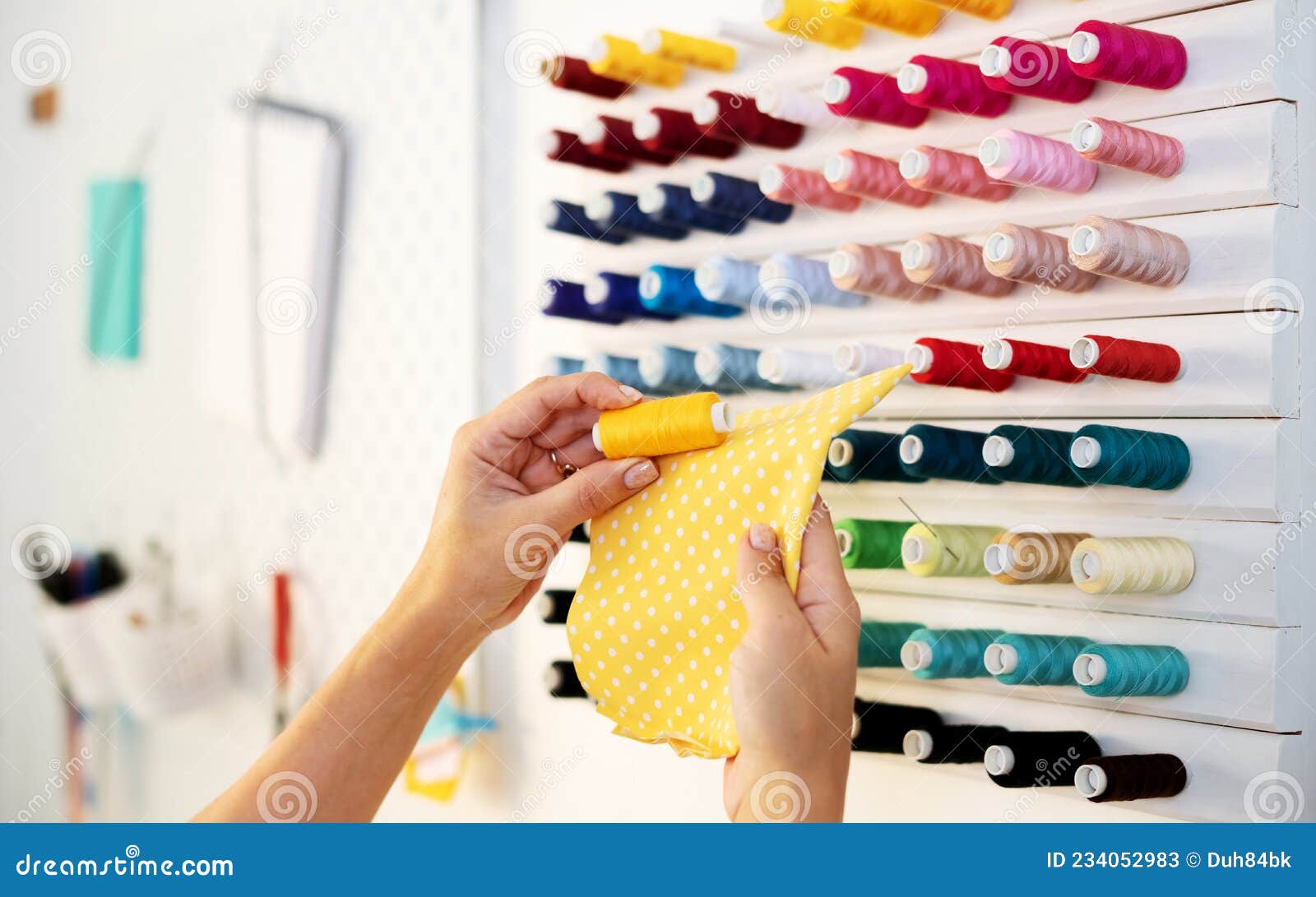 A Girl Tailor Selects Threads for Colored Fabric. Close-up of Hands ...