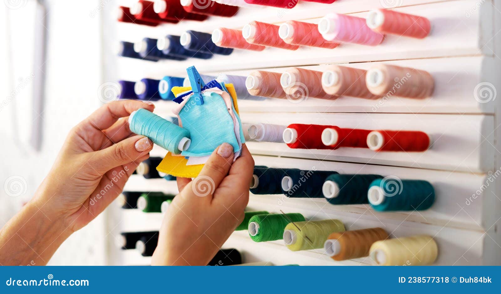 A Girl Tailor Selects Threads for Colored Fabric. Close-up of Hands ...