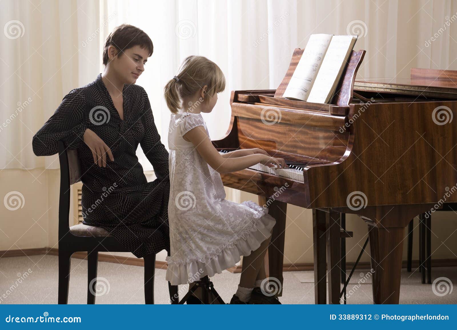 Girl and Teacher Playing Piano Stock Photo - Image of adult, lessons ...