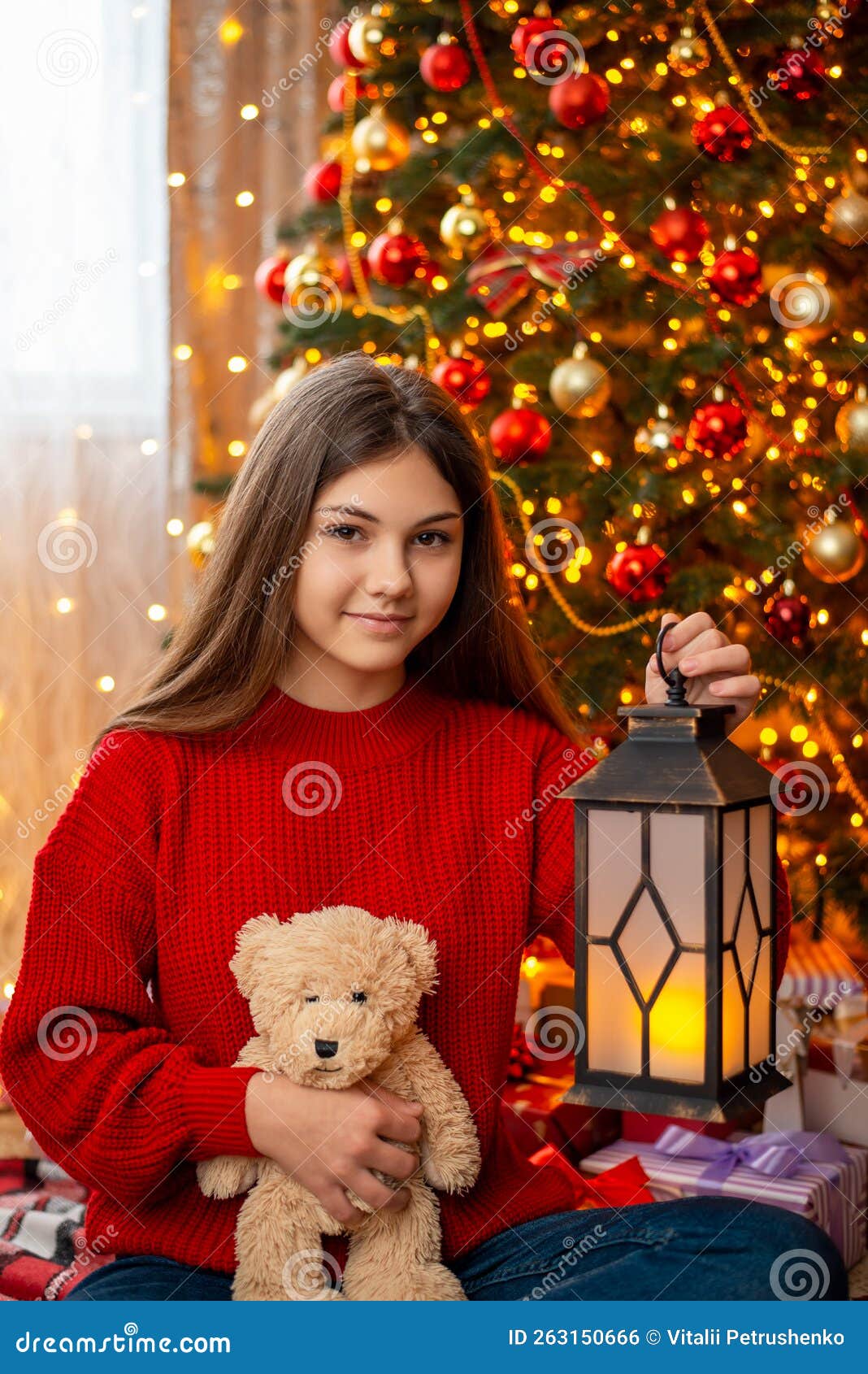 Girl With Teddy Bear And Lantern Sitting Under Christmas Tree Stock