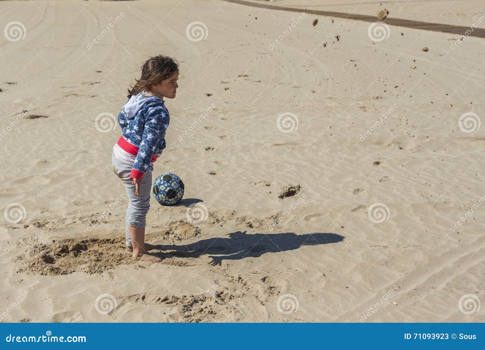 Girl Throwing a Ball of Wet Sand in the Beach in a Windy Day in Stock ...