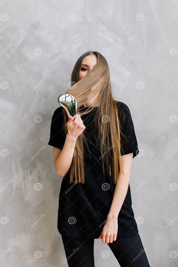 Girl Touching Her Hair And Smiling While Posing At Interior Looking In