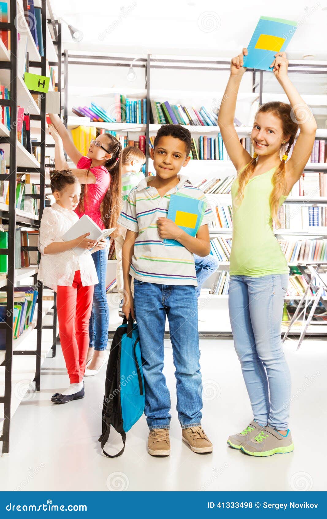 Girl Tries To Hit Boy with Book in Library Stock Photo - Image of shelf ...
