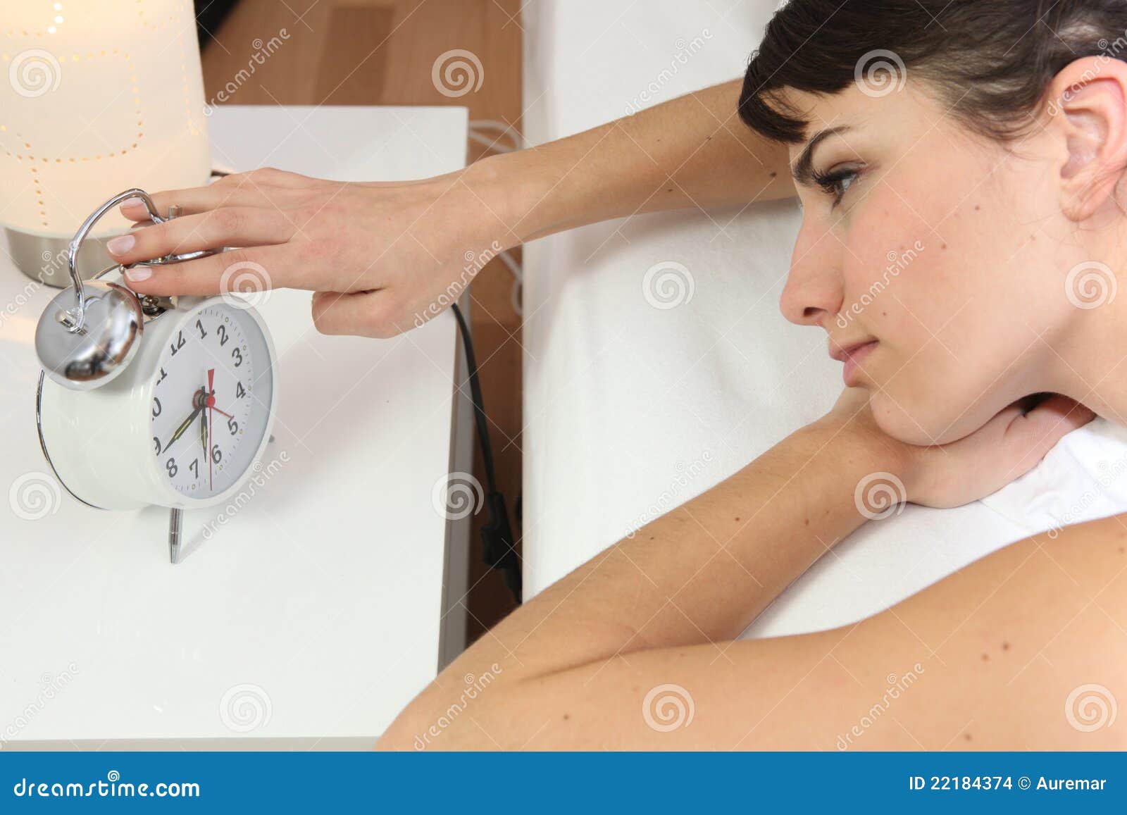 Girl turning off her clock stock photo. Image of time - 22184374