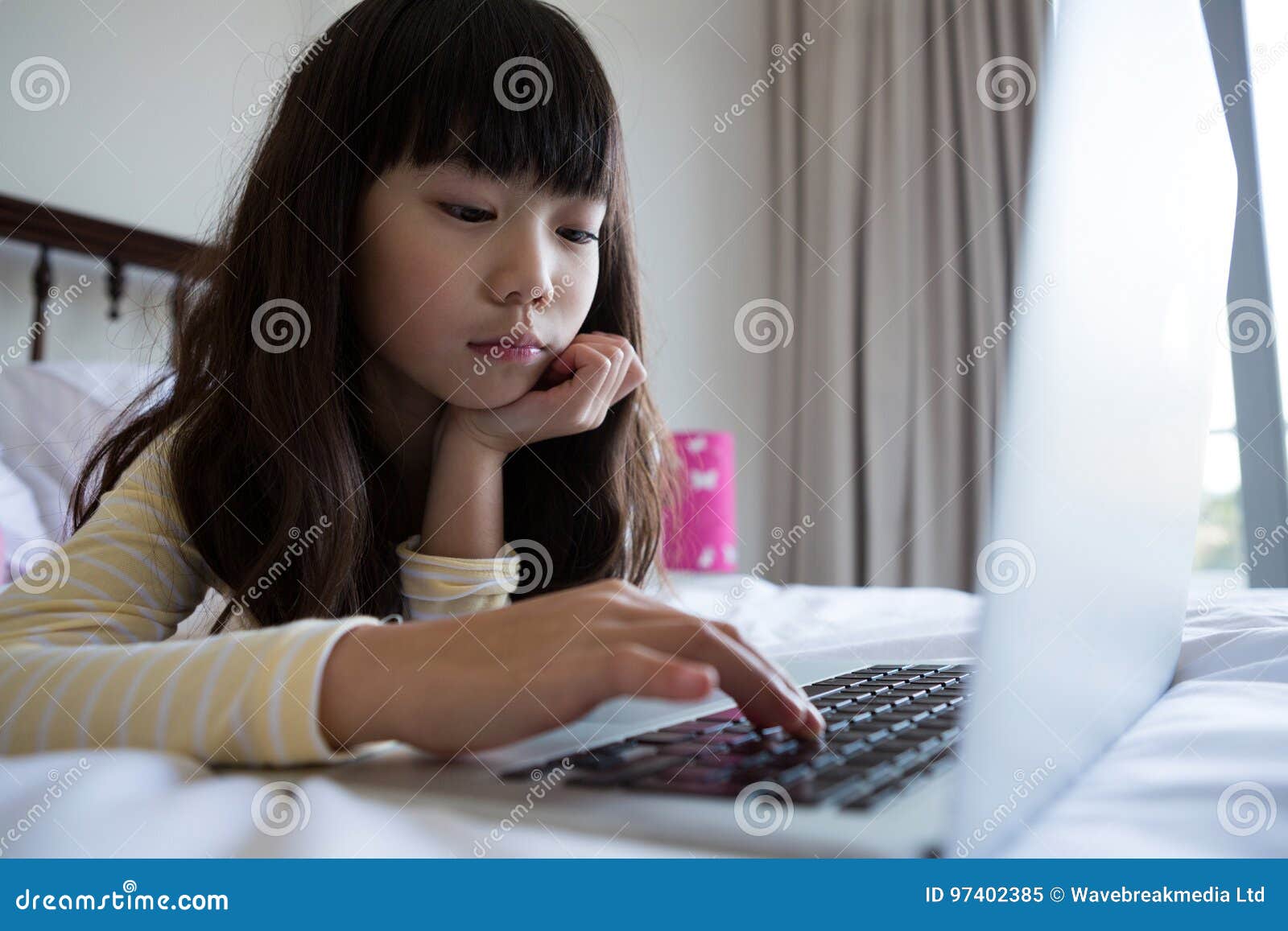 Girl Using Laptop while Lying Down on Bed Stock Image - Image of bangs ...