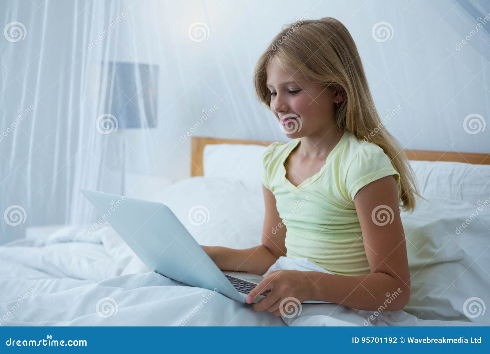 Girl Using Laptop while Sitting on Bed Stock Photo - Image of ...
