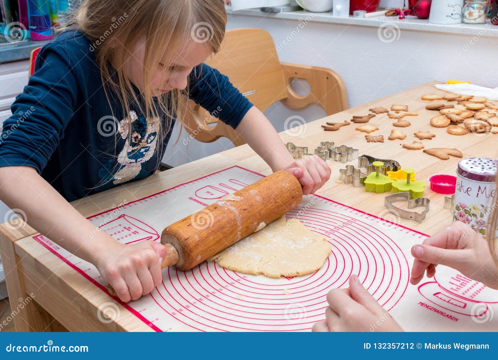 A Girl is Using the Rolling Pin To Roll Out the Dough on the Tab Stock ...