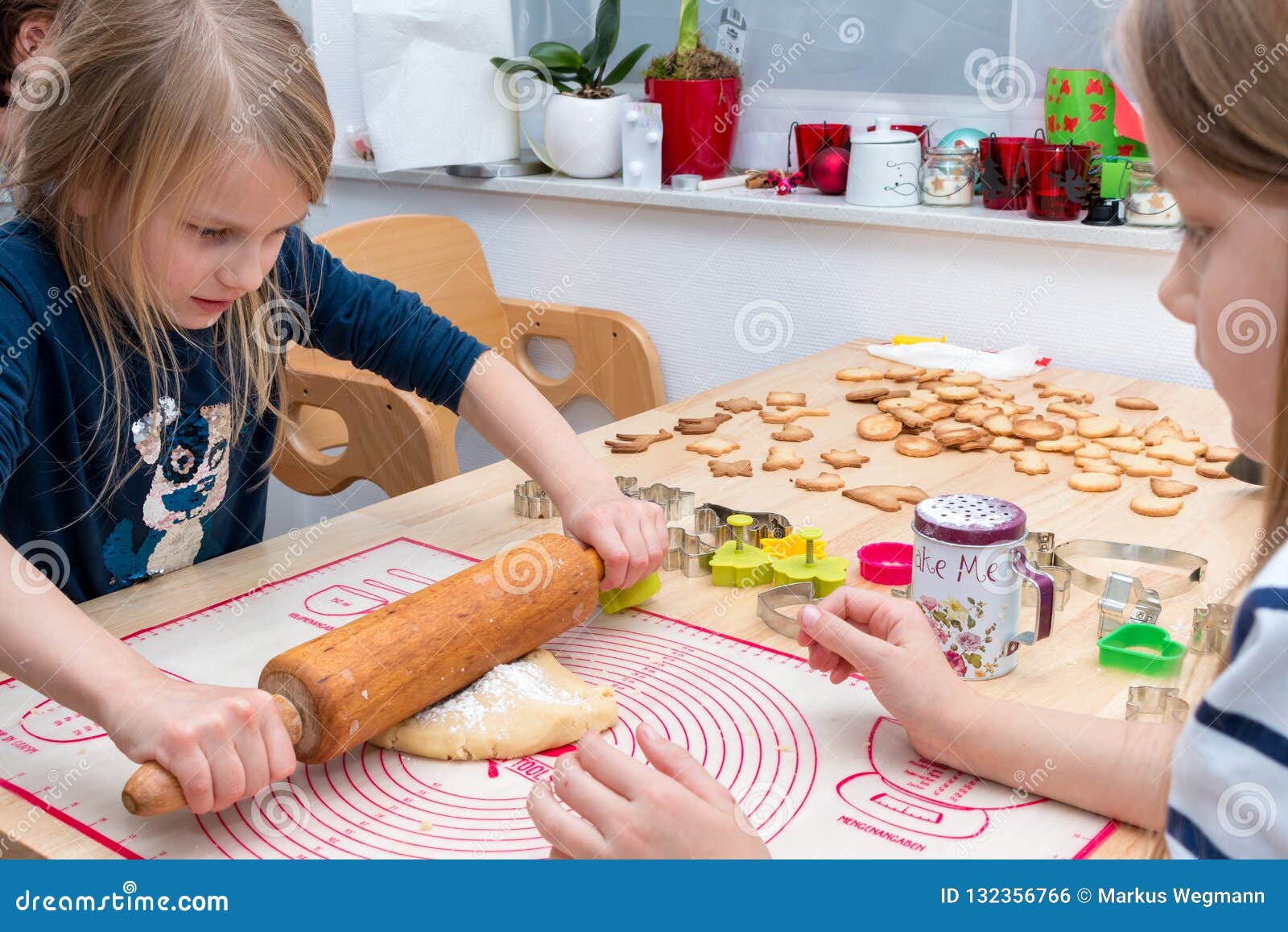 A Girl is Using the Rolling Pin To Roll Out the Dough on the Tab Stock ...