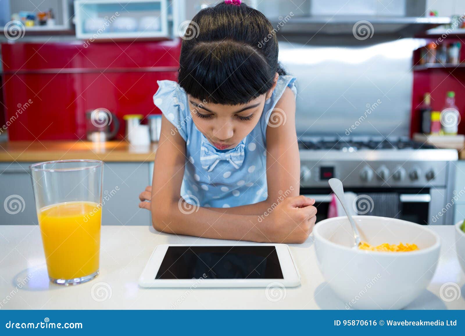 Girl Using Tablet Computer while Sitting with Breakfast in Kitchen ...