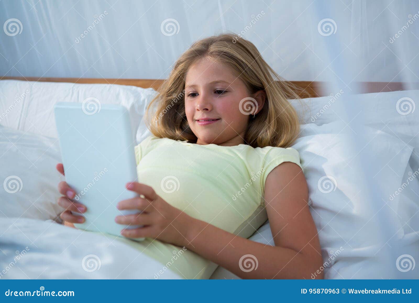 Girl Using Tablet while Lying on Bed Stock Image - Image of bedroom ...