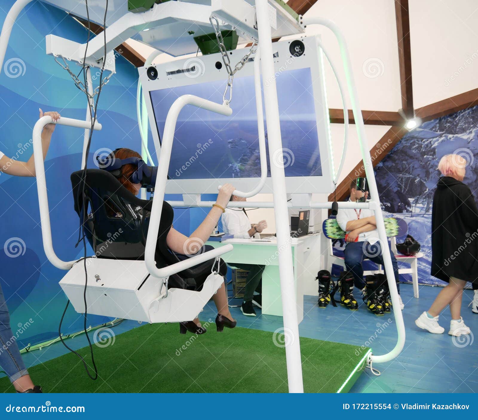 A Girl on a Virtual Hang Glider Ride Sits in a Virtual Reality Helmet ...