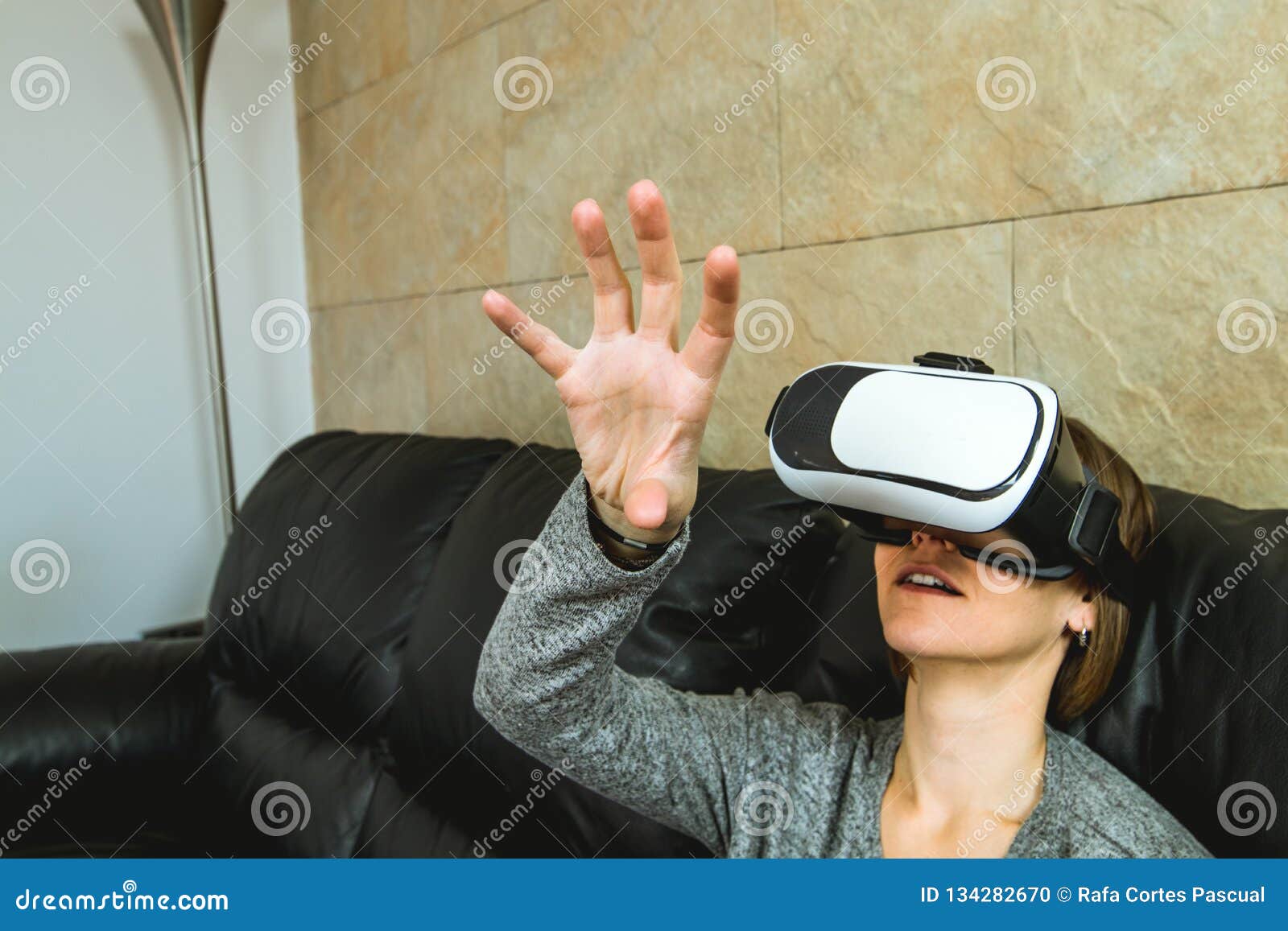 A Girl with VR Glasses on the Couch Touching with a Finger. Virtual ...