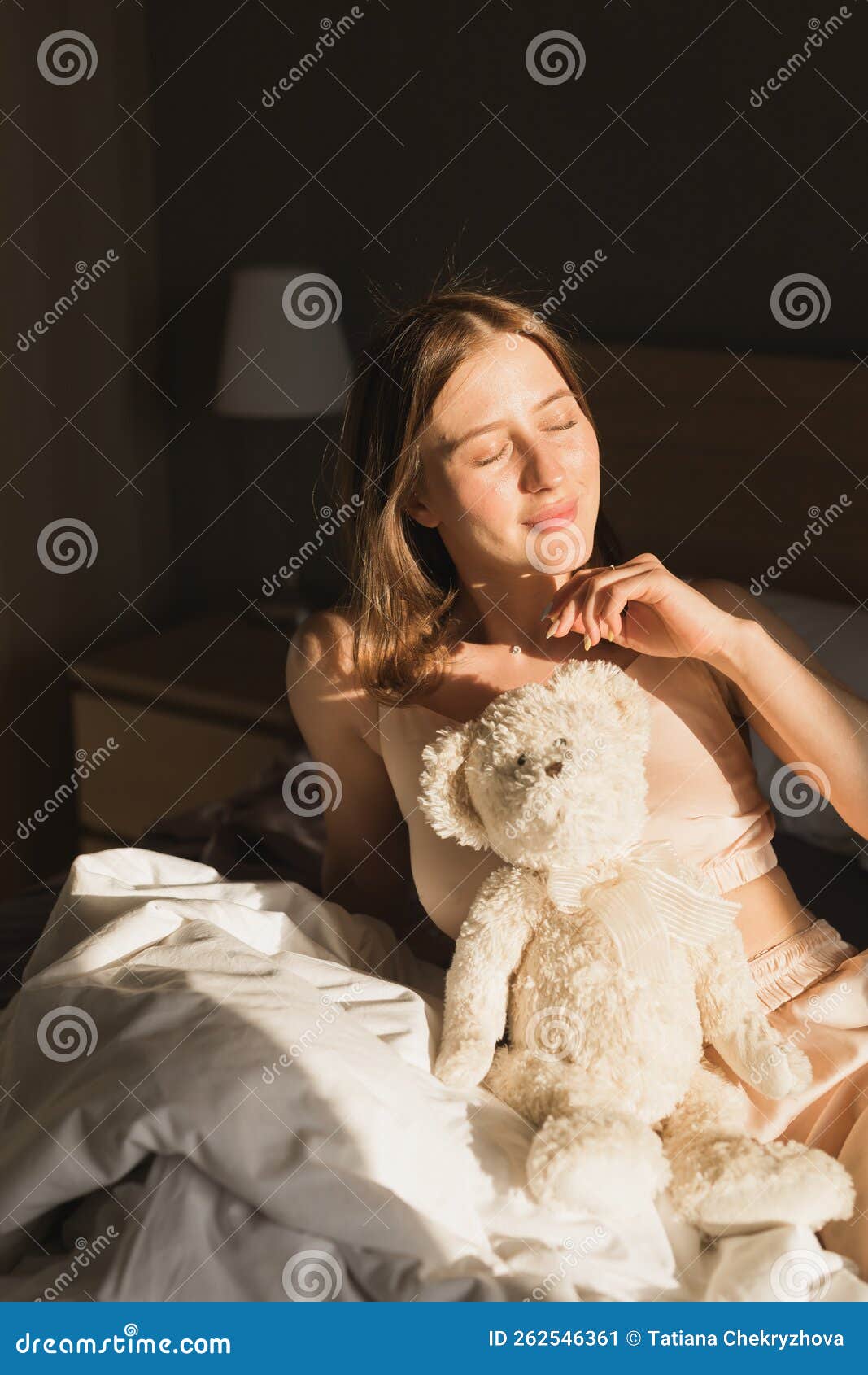 Portrait Of Girl Is Waking Up In Morning Stretches In Bed And Sun
