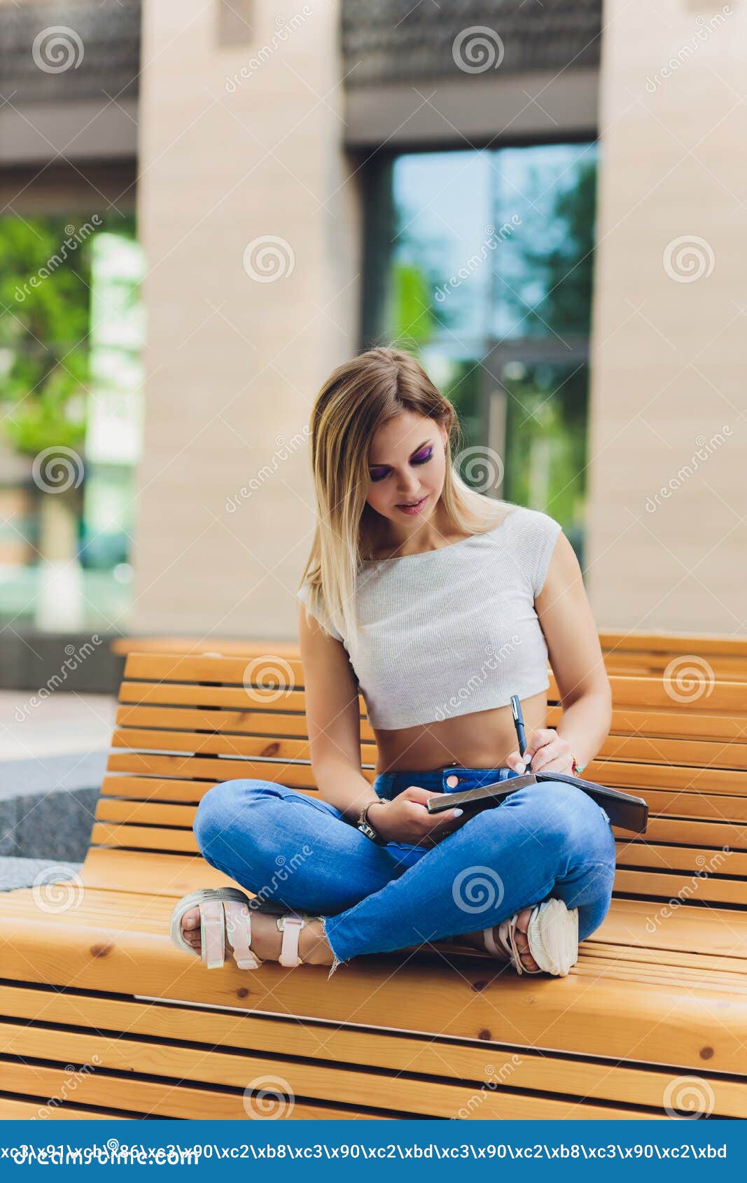 Girl Writes in a Notebook, Sitting on a Bench in the Park. Stock Photo ...