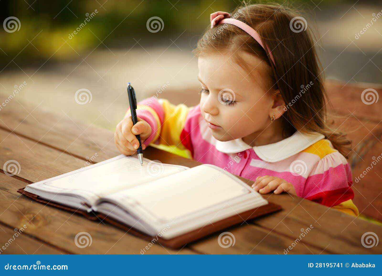 Girl writes to the notepad stock image. Image of little - 28195741