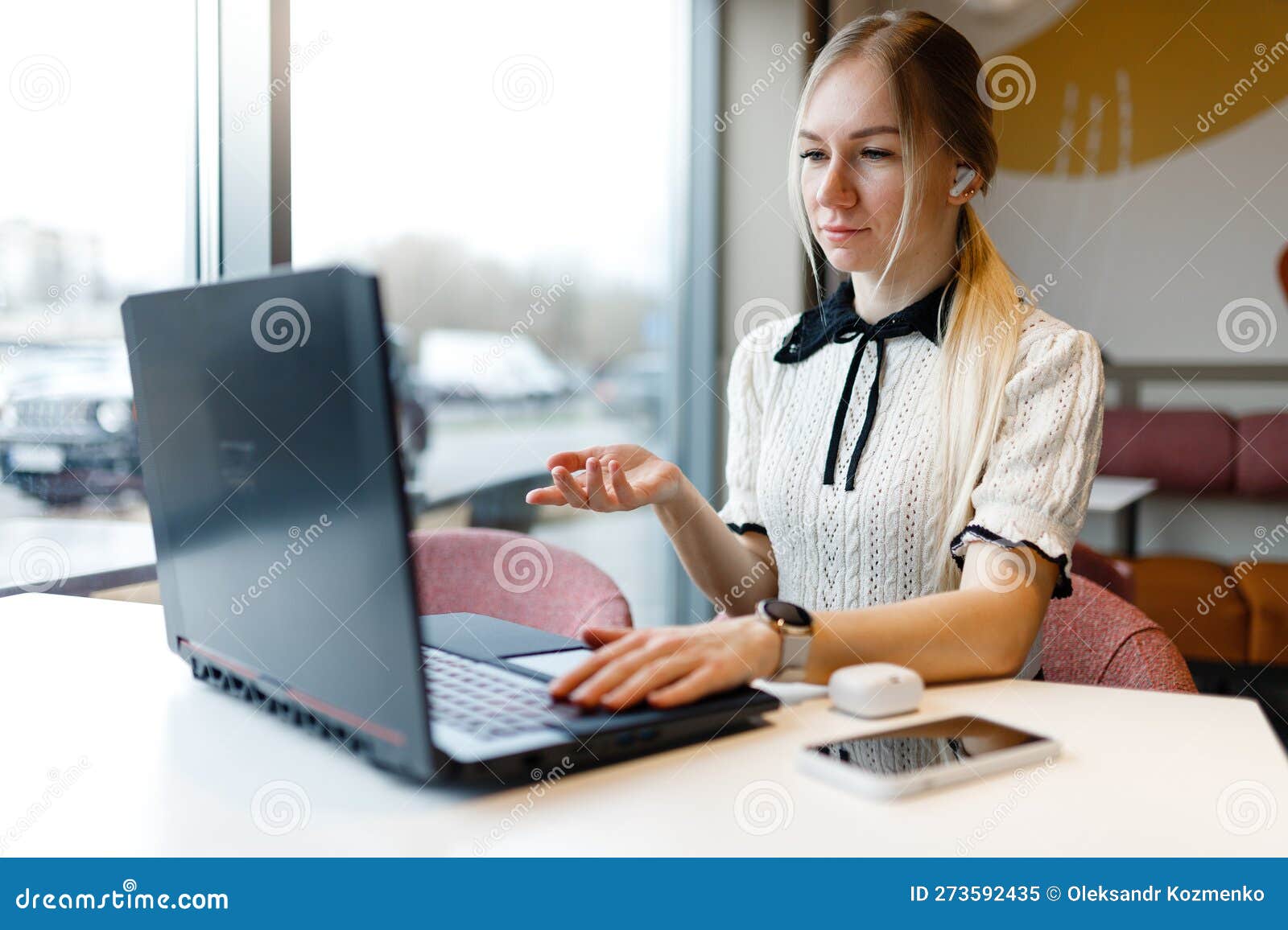 A Girl Works at a Computer in a Coffee Shop. Stock Image - Image of ...