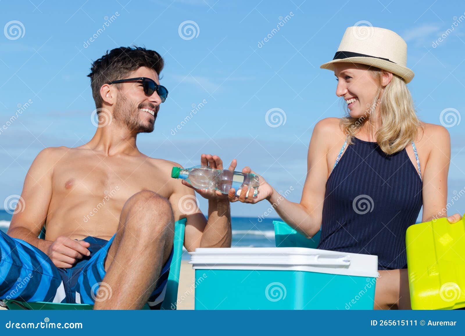 Girlfriend Giving Bottled Water To Partner while Sunbathing Stock Image ...