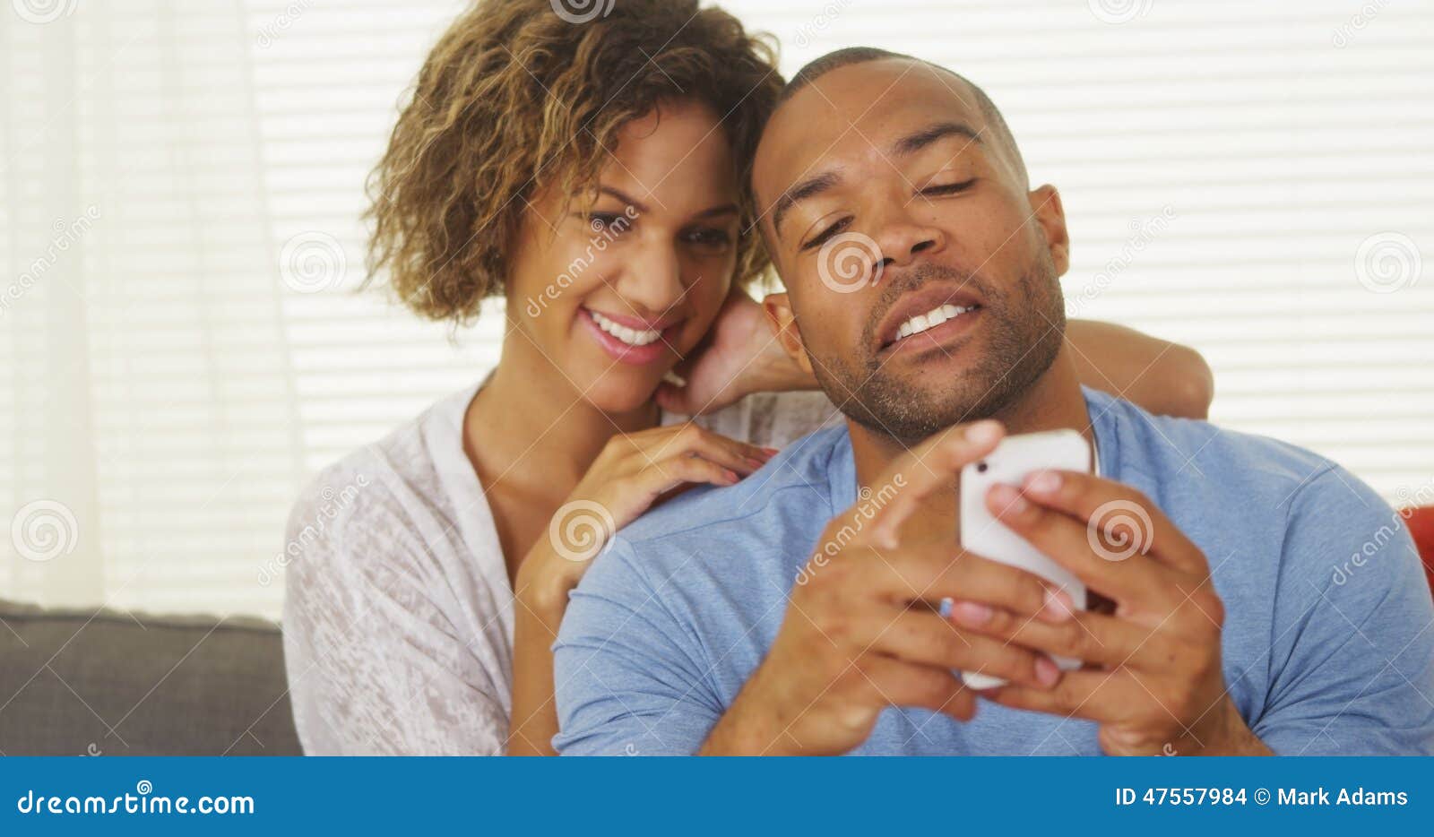 Girlfriend Watching Over Boyfriend S Shoulder As he Texts Stock Photo ...