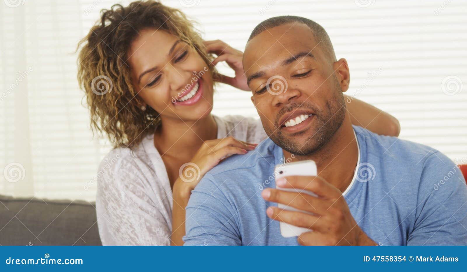 Girlfriend Watching Over Boyfriend S Shoulder As he Texts Stock Photo ...
