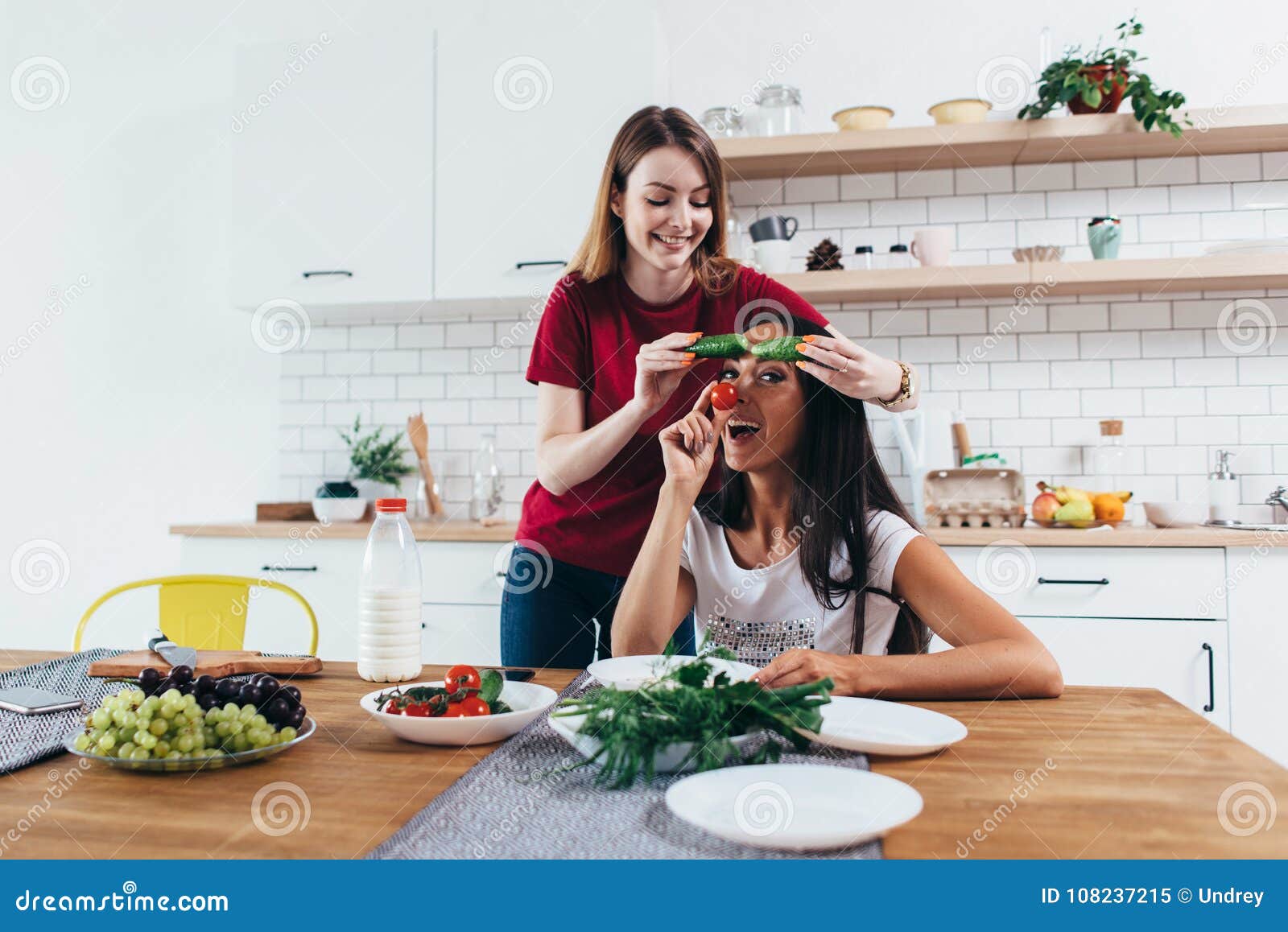 Girls Fooling Around in the Kitchen Playing with Vegetables. Stock ...