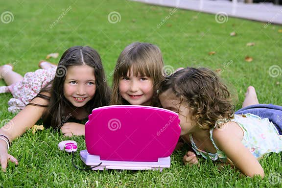 Girls Playing with Toy Computer in Grass Stock Photo - Image of face ...