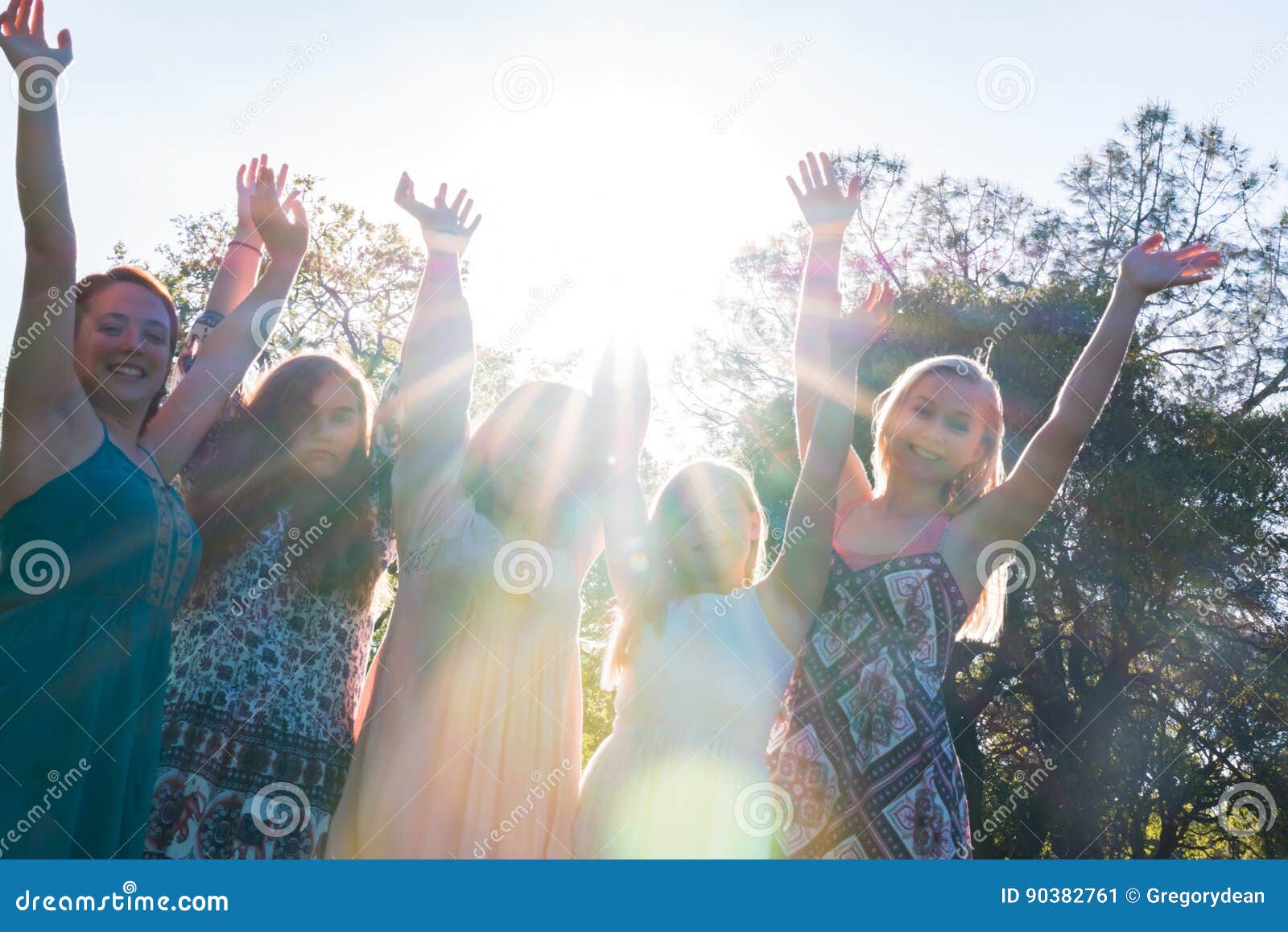 Girls Standing with Arms Raised and Sunlight Overhead Stock Image ...