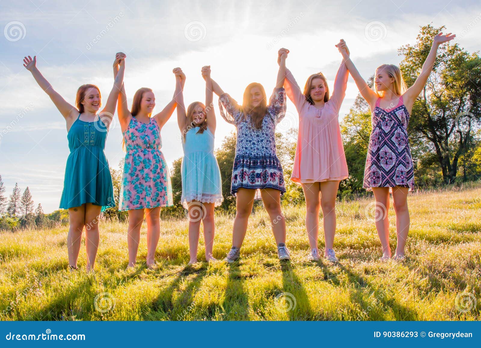 Girls Standing with Arms Raised and Sunlight Overhead Stock Image ...