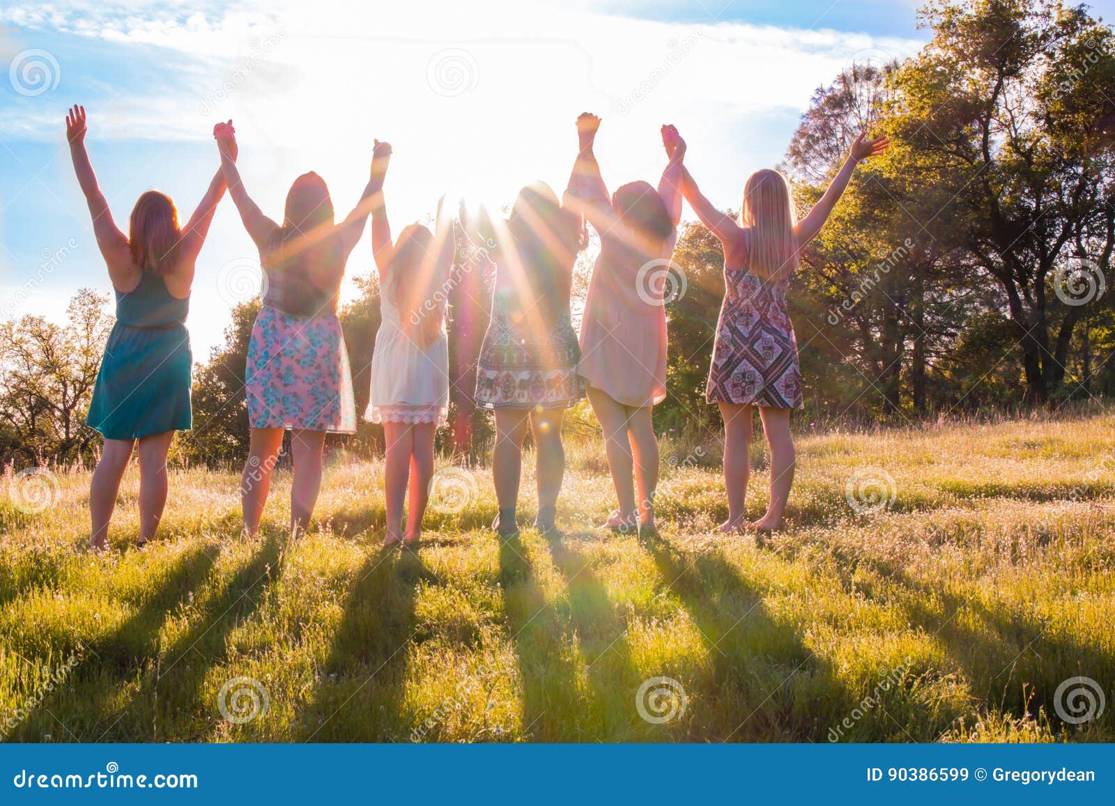 Girls Standing with Arms Raised and Sunlight Overhead Stock Image ...