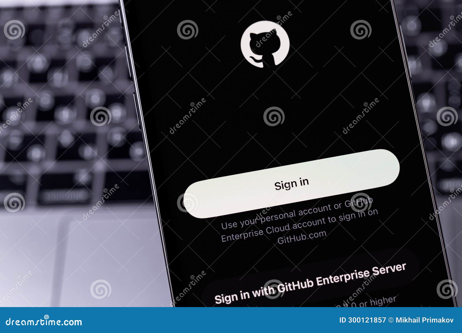 GitHub Logo Mobile App on a Screen Smartphone and Notebook Closeup. GitHub is the Largest Web ...
