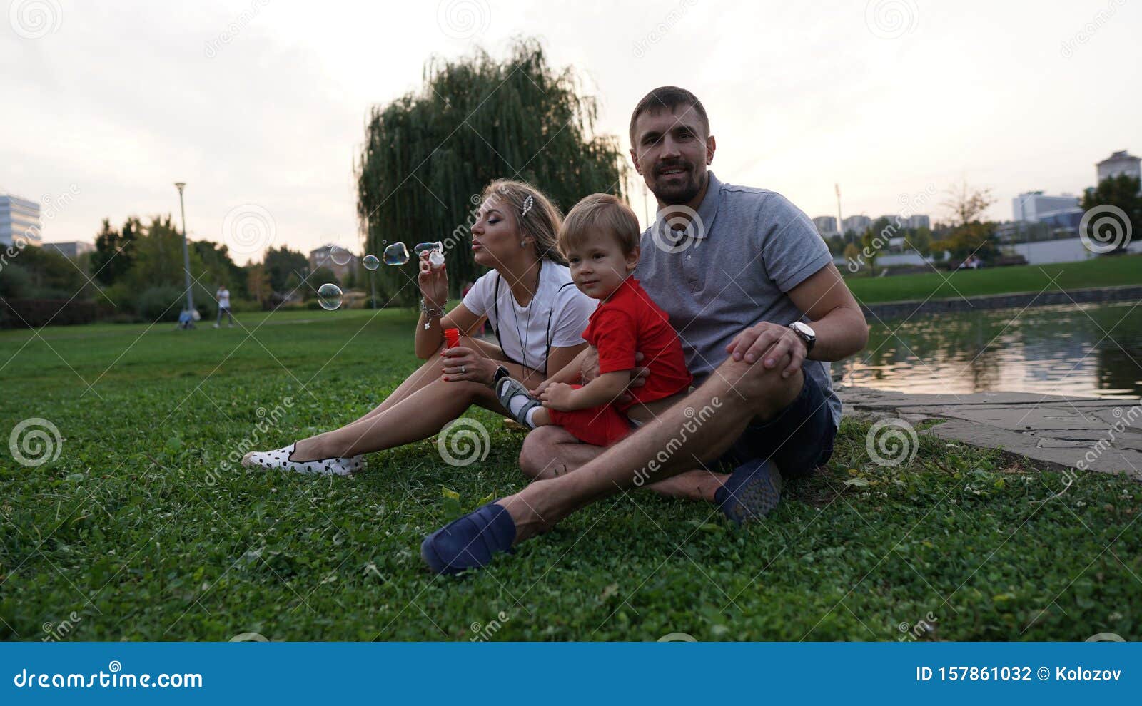 Glad Familj Pappa Mamma Och Liten Son Som Sitter På Gräs I Parken På