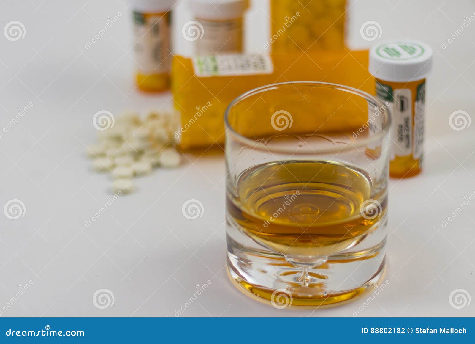 A Glass of Alcohol and Several Bottles of Pharmaceuticals Stock Photo ...