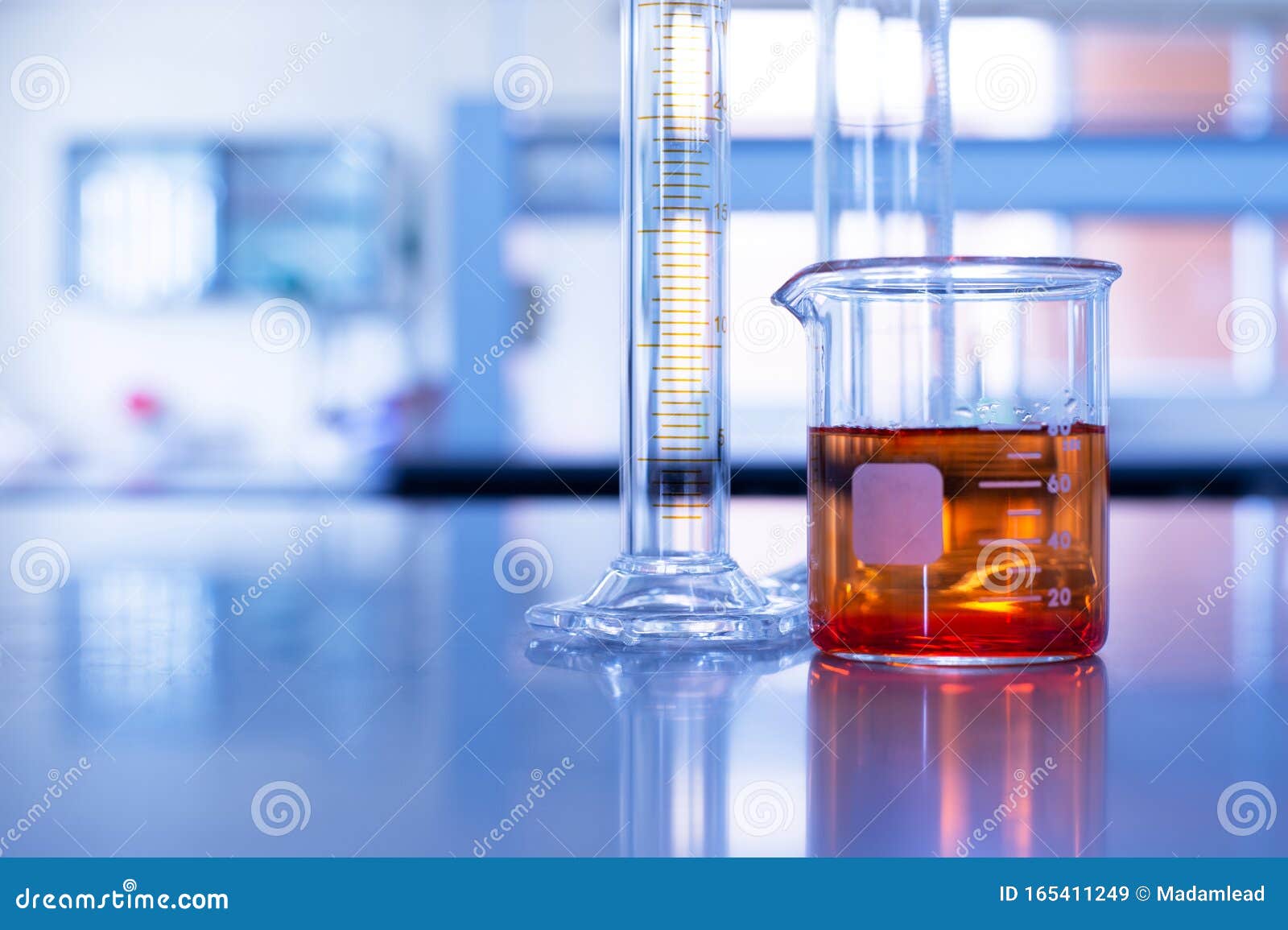 Glass Beaker with Orange Solution and Cylinder in Blue Chemistry ...