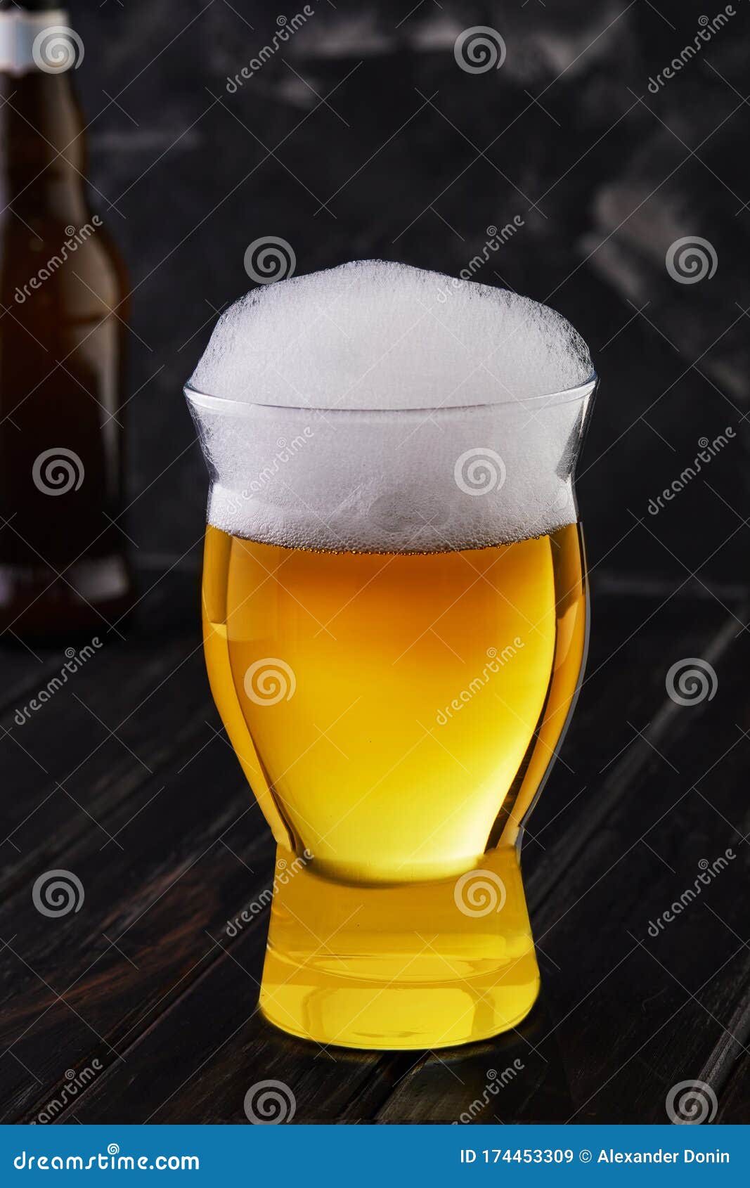 A Glass of Beer with Copious Foam at the Top of the Glass, on a Black ...