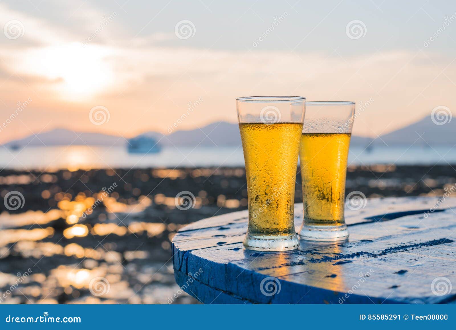 Glass of beer on a sunset stock image. Image of sand - 85585291