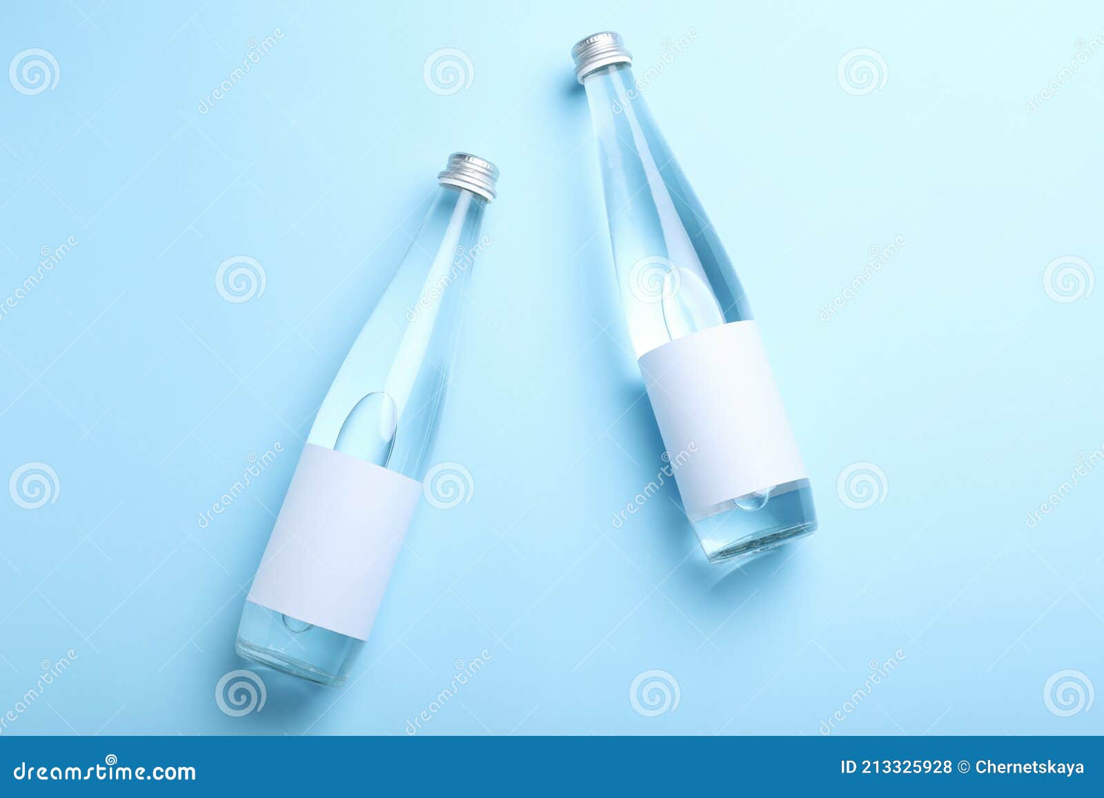 Glass Bottles of Water with Blank Label on Light Blue Background, Flat ...