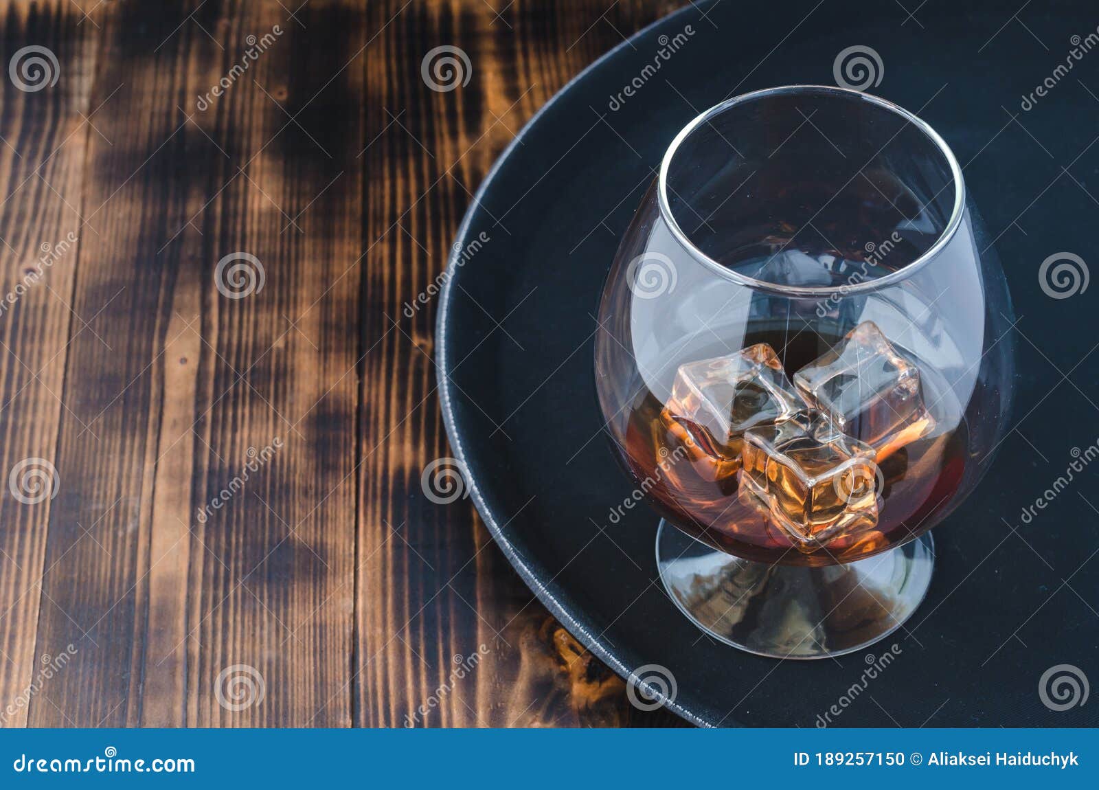Glass of Brandy with Ice Cubes/Glass of Brandy with Ice Cubes on a ...