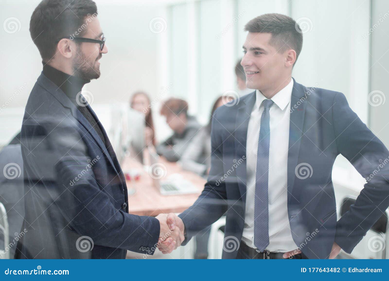 Through the Glass. Business Partners Handshake in the Office Stock ...