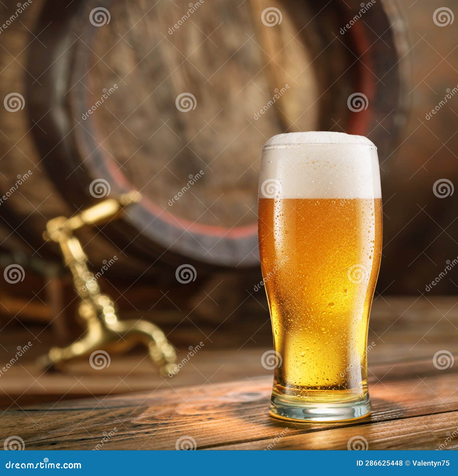 Glass of Chilled Beer and Wooden Beer Cask at the Background Stock ...
