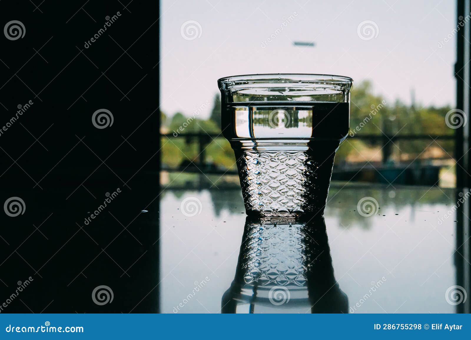 A Glass with Clean Clear Water and Sharp Shadows Stands on a White ...