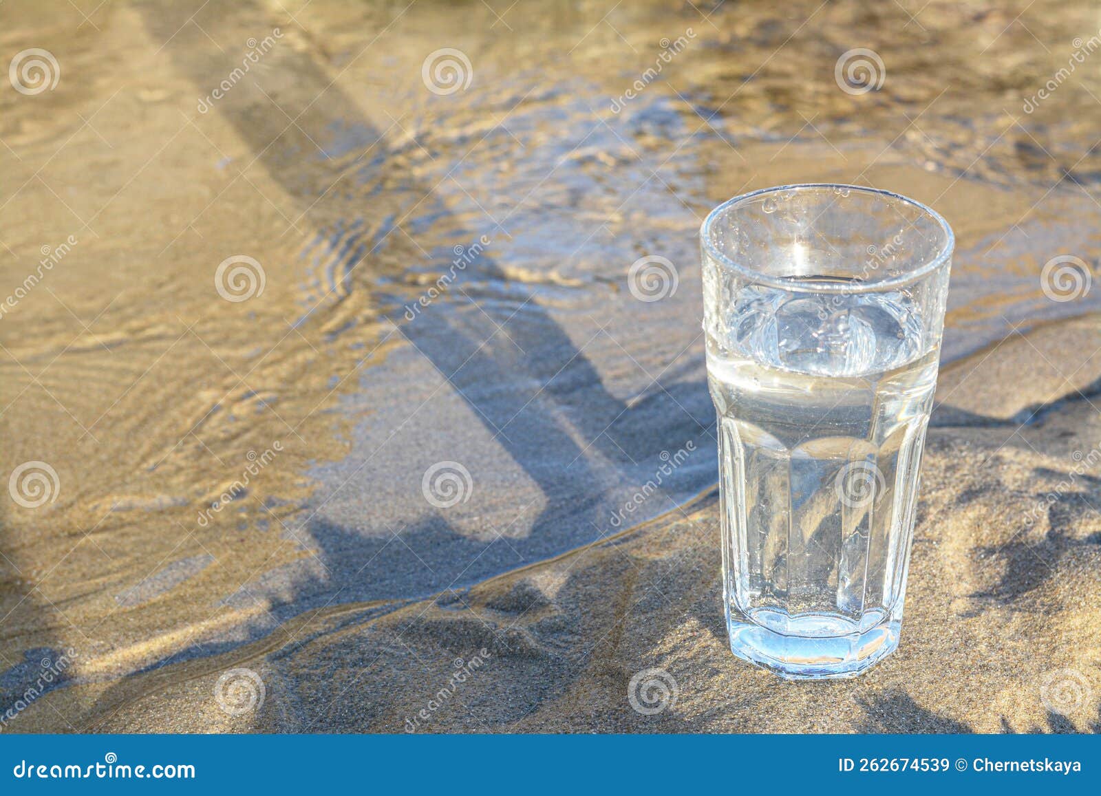 Glass of Clean Water on Wet Sand Outdoors. Space for Text Stock Image ...