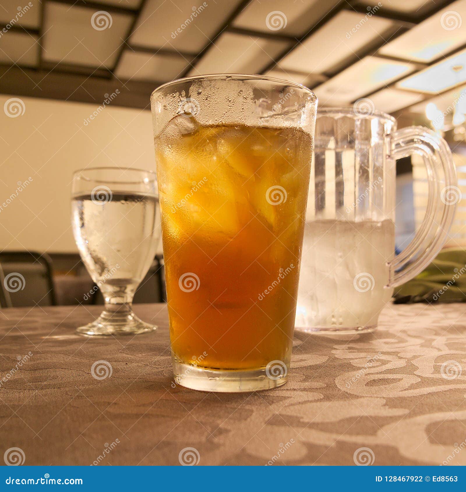 Glass of Cold Iced Tea with Ice and Goblet and Pitcher of Water Stock ...